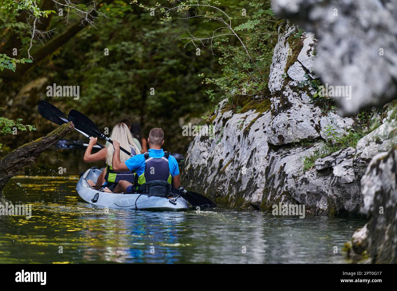 A young couple enjoying an idyllic kayak ride in the middle of a ...