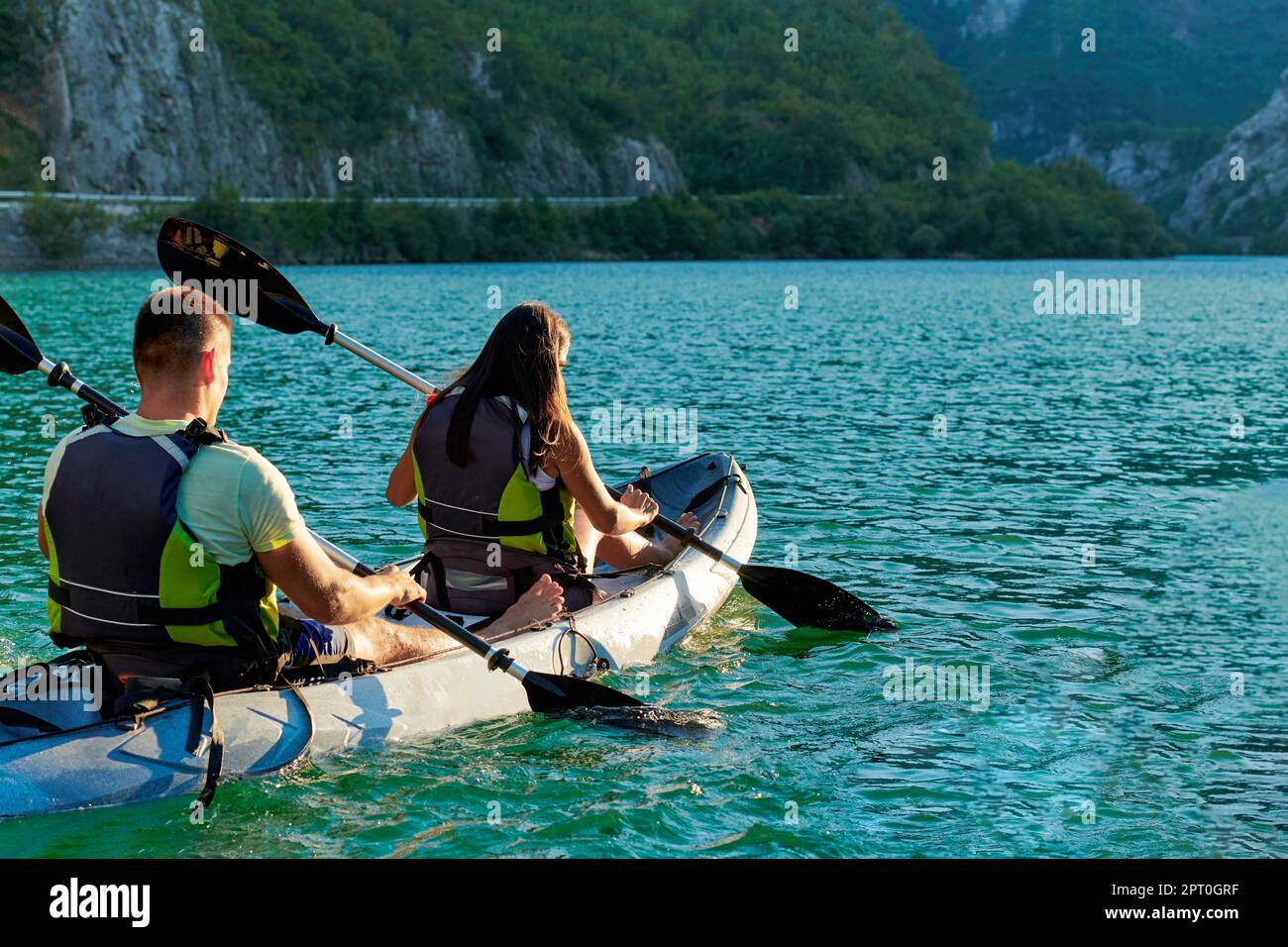 A young couple enjoying an idyllic kayak ride in the middle of a ...