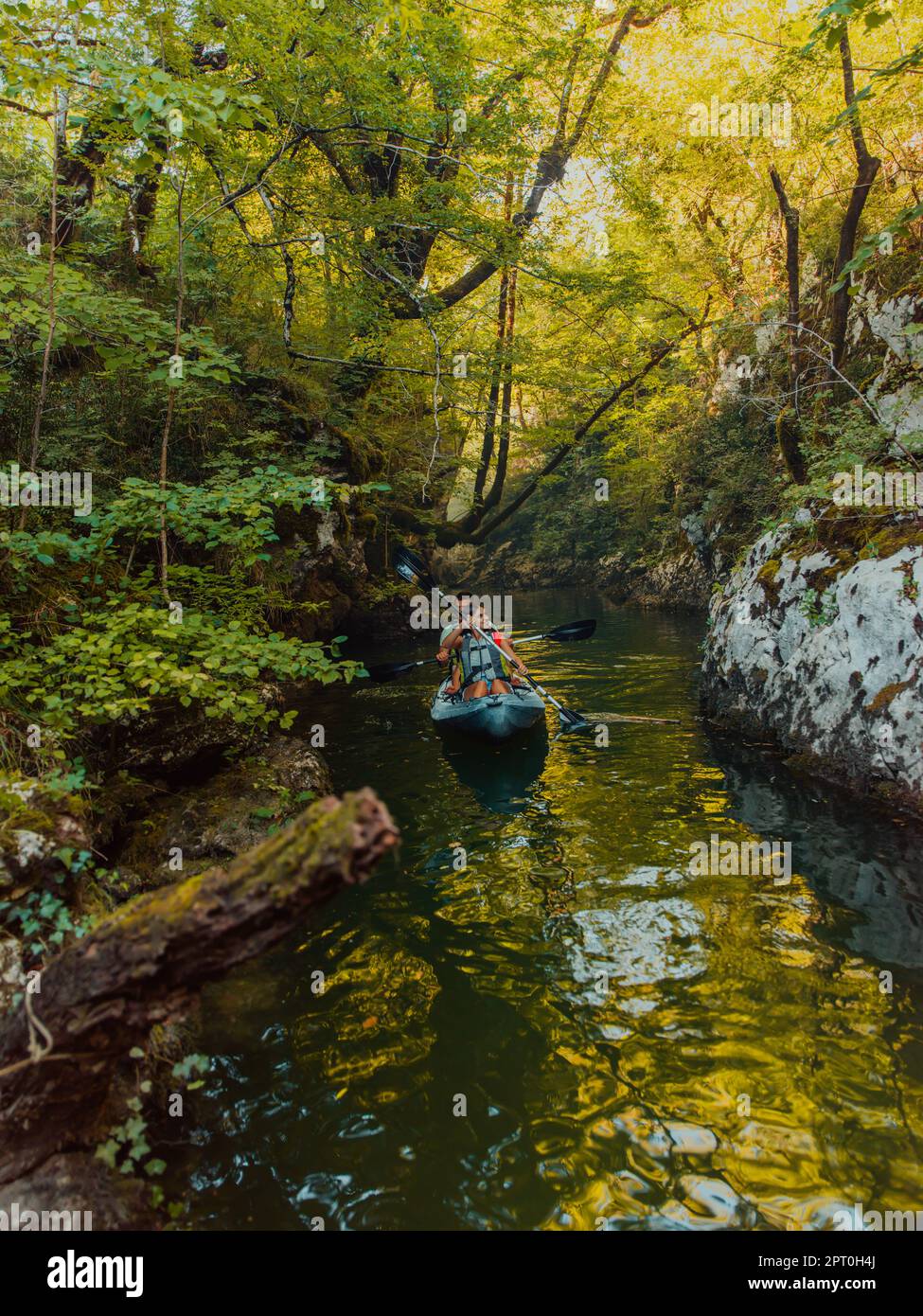 A young couple enjoying an idyllic kayak ride in the middle of a ...