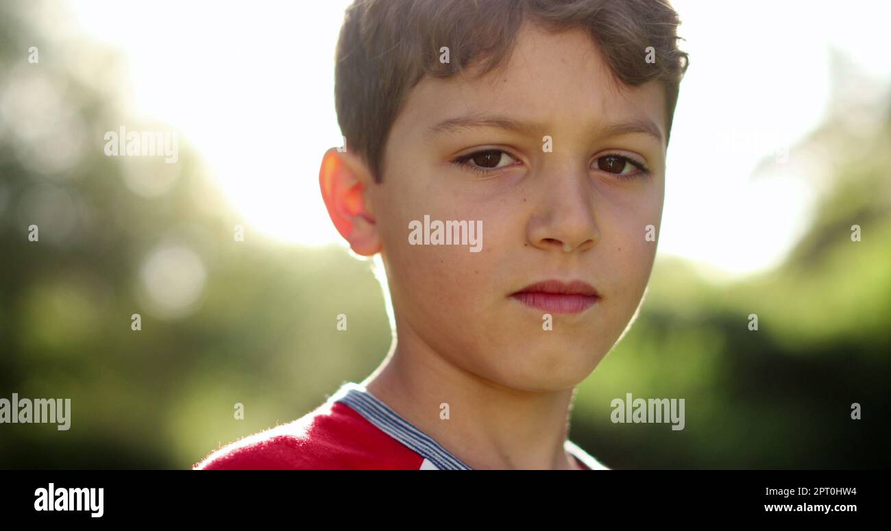 Young boy child face in outdoor park with lens-flare, kid looking to ...