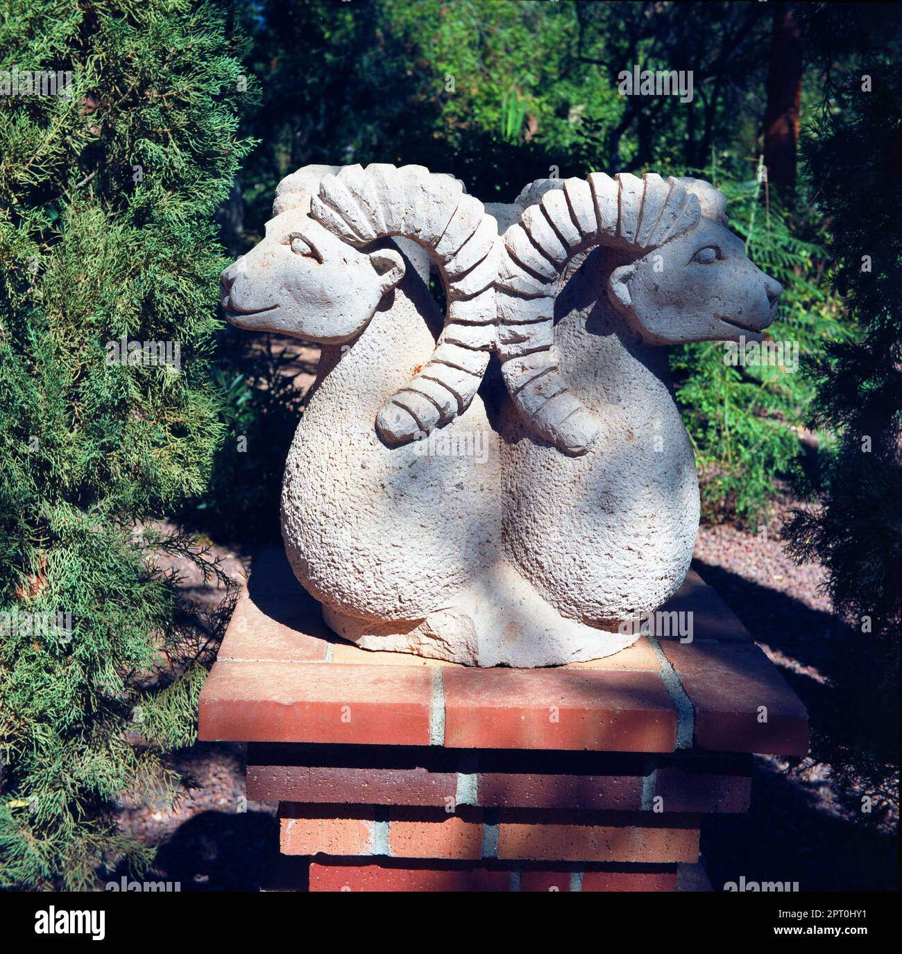 Double head ram stature in a garden Stock Photo - Alamy