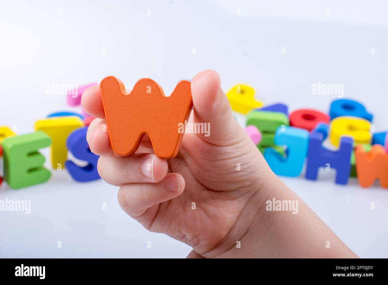 Hand holding letter cube W of made of wood Stock Photo - Alamy