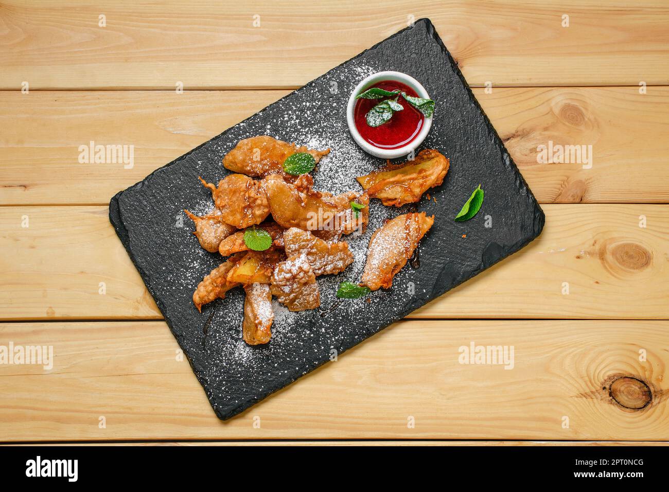 Overhead view of deep fried fruits in breading served with caramel and ...