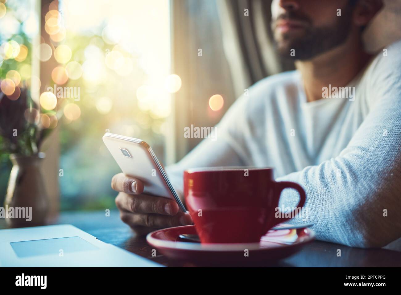 Coffee and connectivity. a young man using his cellphone in a coffee ...