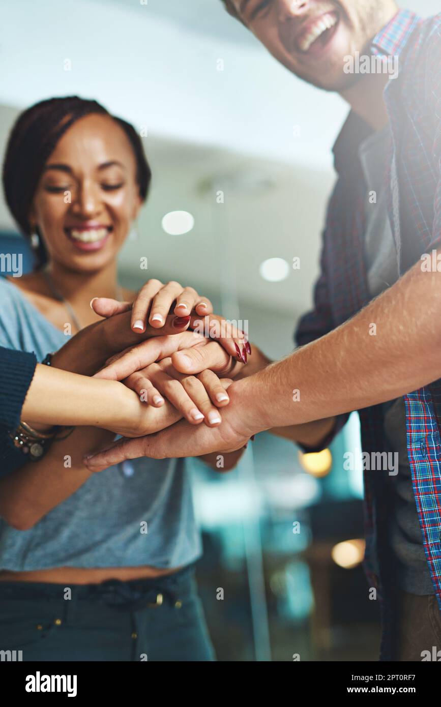 We work together, we win together. a group of colleagues joining their ...