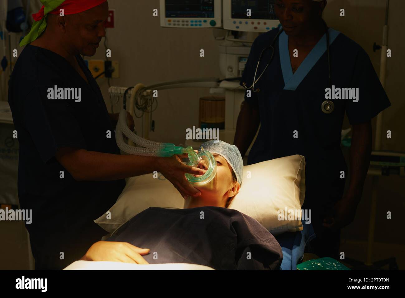 The patient is asleep now. a surgeon administering anesthetic to a ...