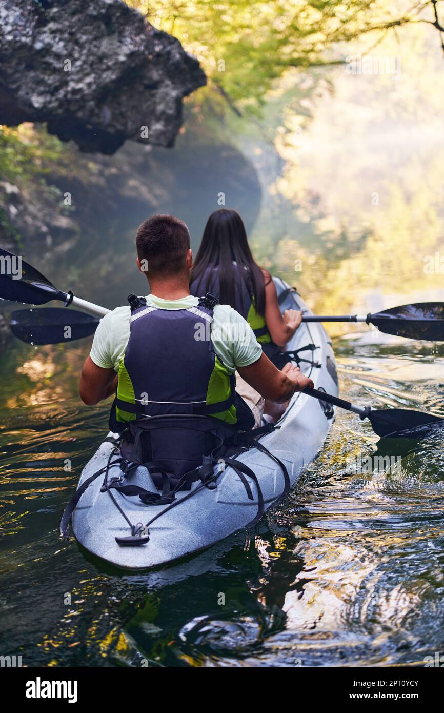 A young couple enjoying an idyllic kayak ride in the middle of a ...