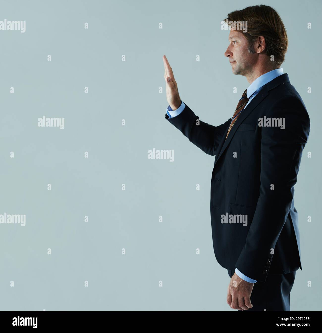 Reaching for success. Profile shot of a businessman holding his arm up ...