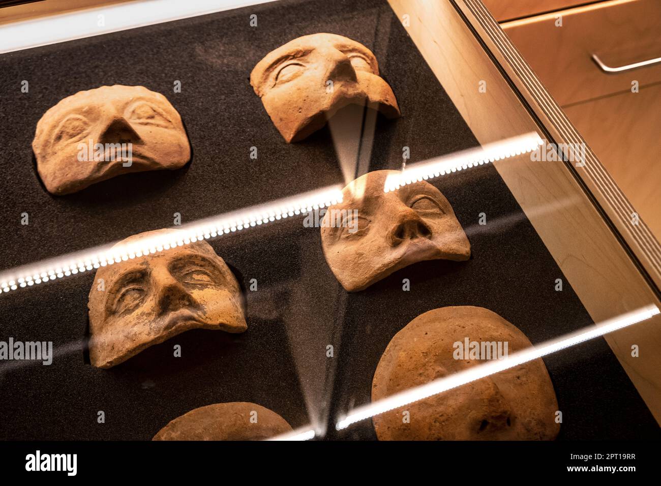 Málaga, Spain -- Ancient clay masks on display in a glass case at the ...