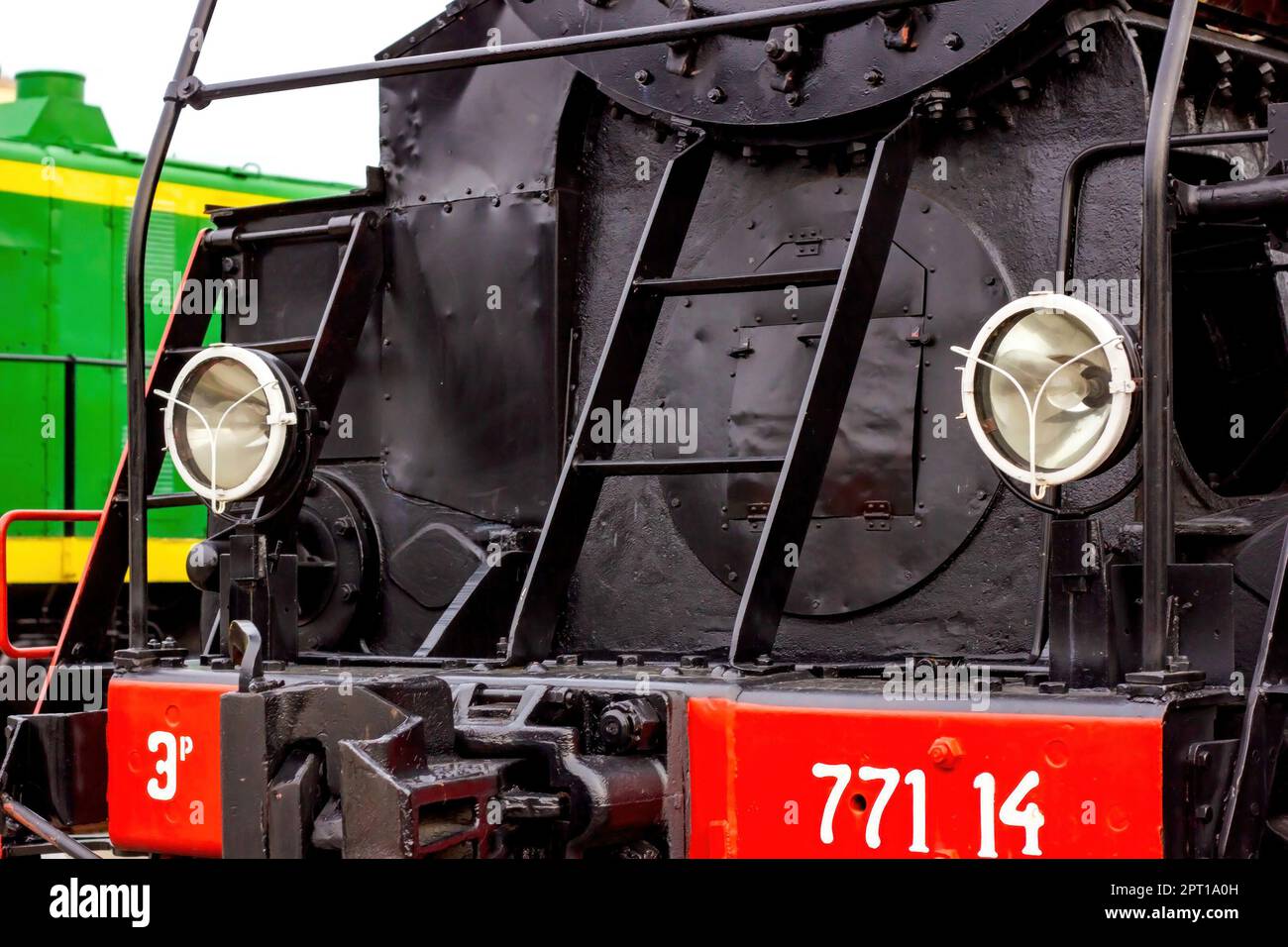 Two electric headlights on a retro train front on the rail platform ...