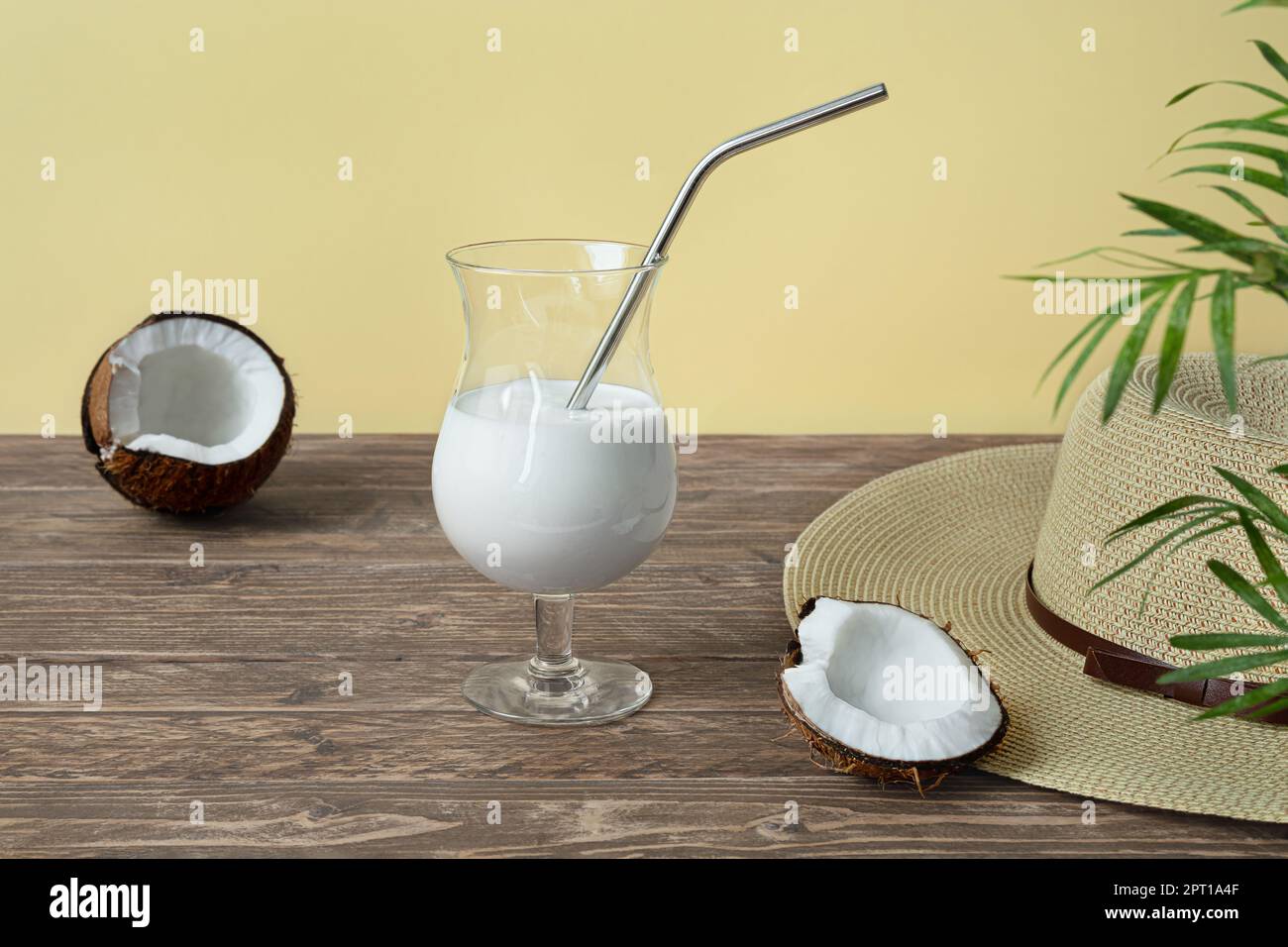 A glass of coconut milk cocktail with reusable metal cocktail tube ...