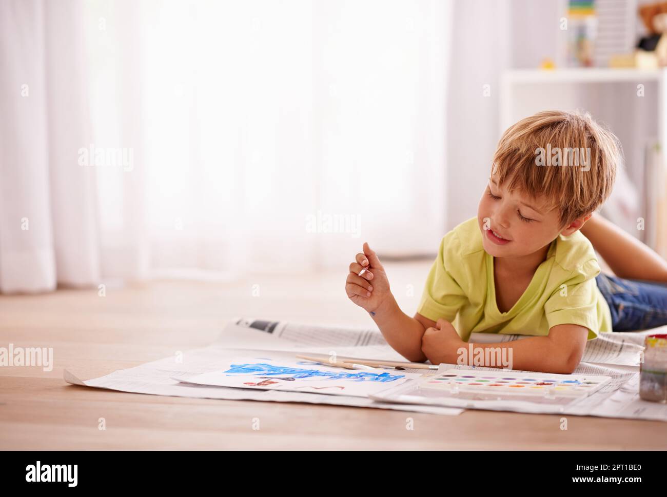 Unleash your childs creativity. a cute little boy painting a picture at ...