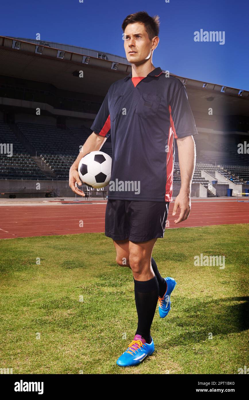 Hes dedicated to his sport. a young footballer standing on a field ...