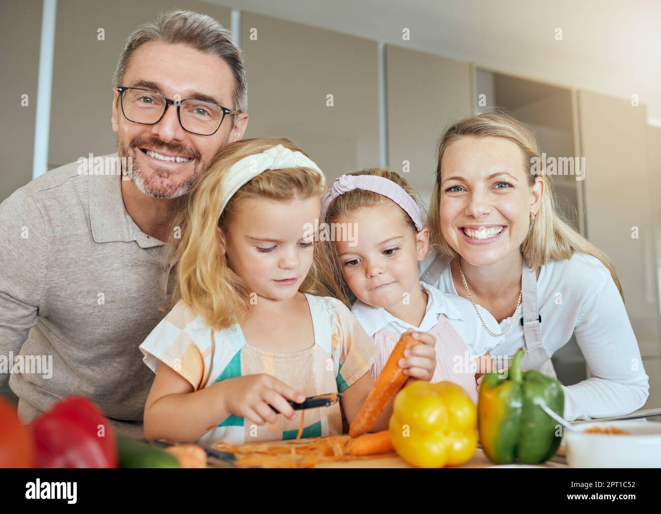 Mom, dad and children in the kitchen, cooking together and learning ...