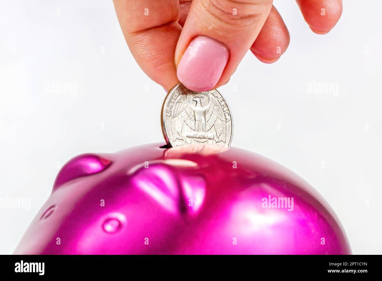 Bright pink pig money box and hand dropping coins on light background ...