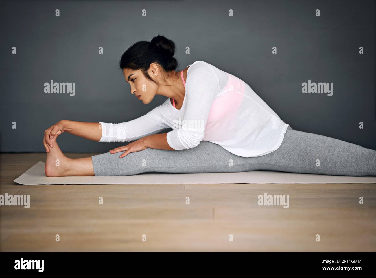 Stretching her way to a stressless life. a young woman stretching ...