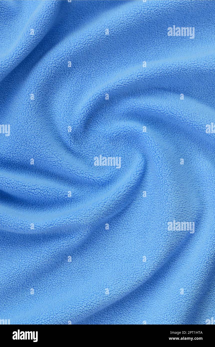The blanket of furry blue fleece fabric. A background of light blue ...