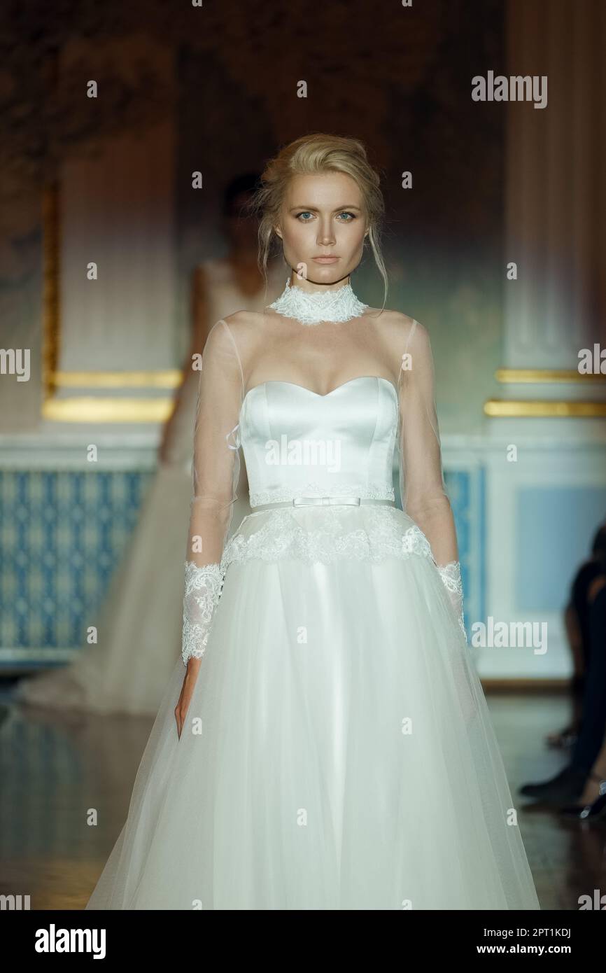 Attractive fashion model on stage in spotlight. Wedding makeup and hair ...