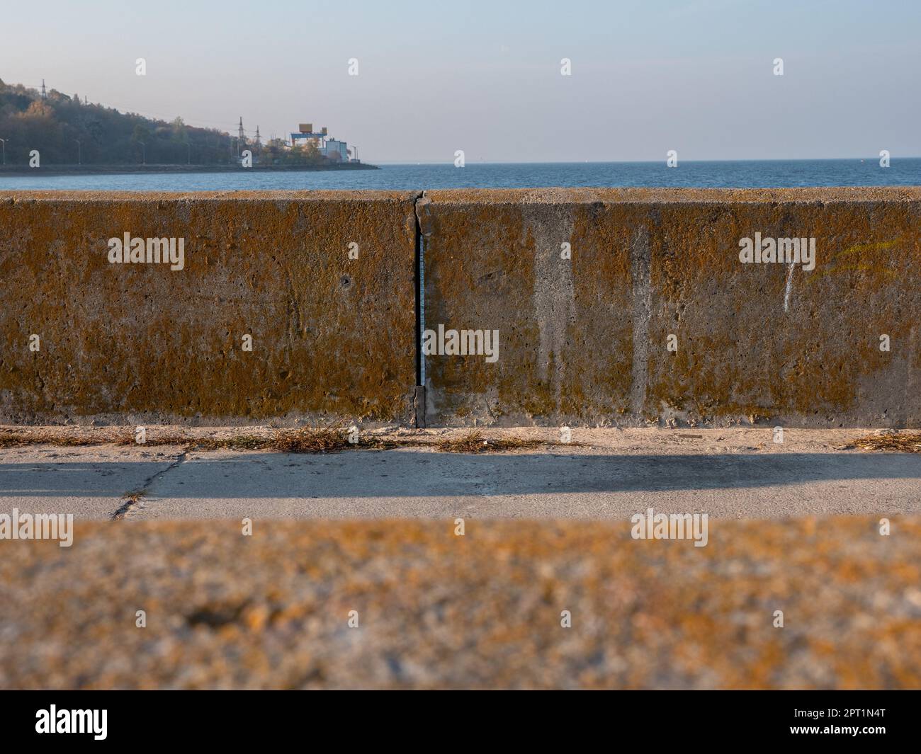 View from the promenade with old concrete blocks fence over the calm ...