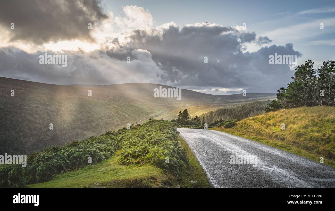 Winding road leading to Lough Tay called The Guinness Lake illuminated ...