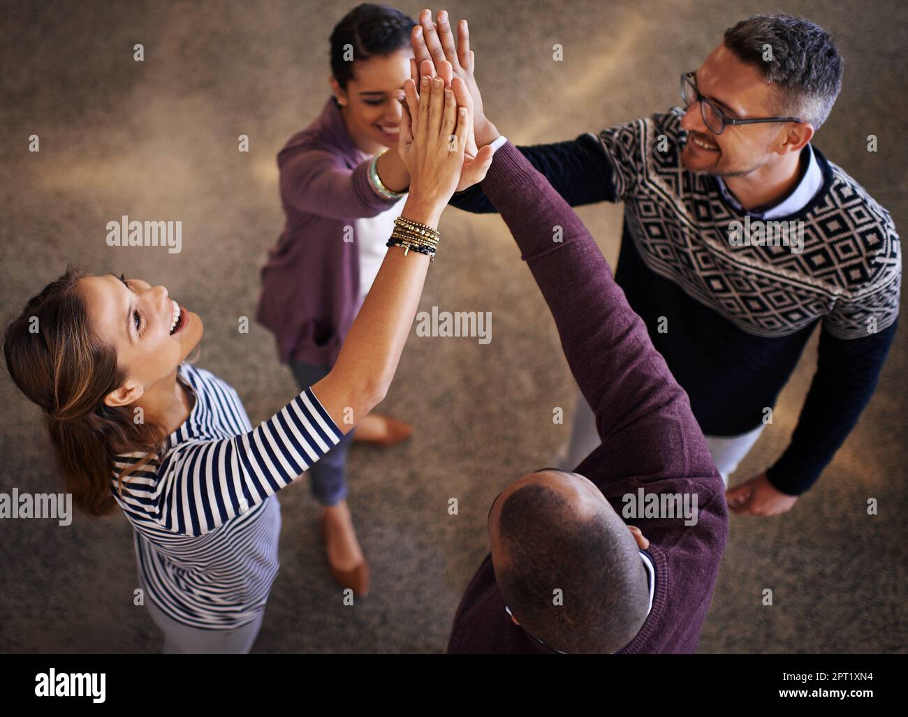 Go team. High angle shot of a group of coworkers giving each other a ...