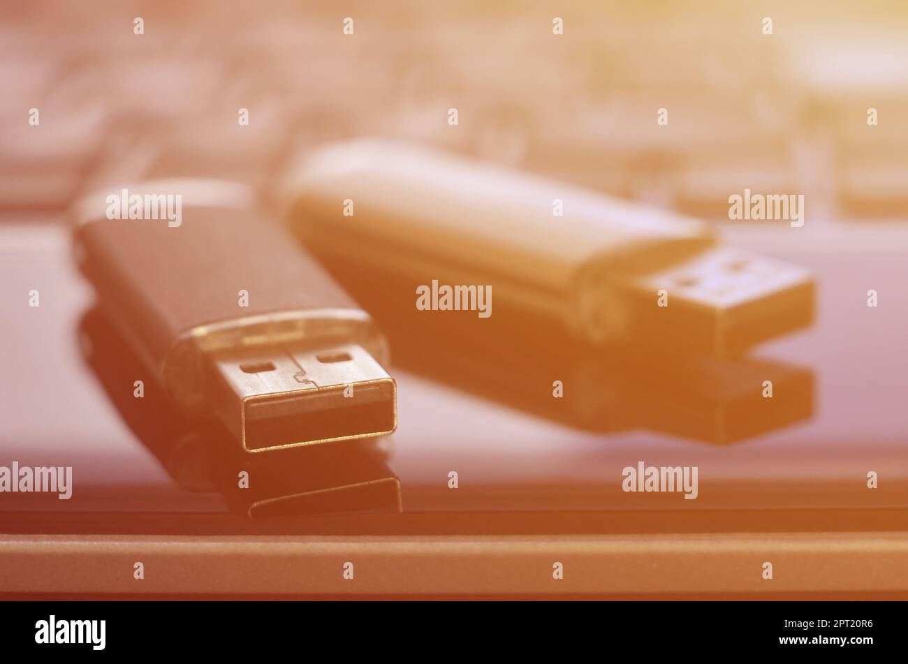 USB flash cards lying on black laptop case in front of his keyboard ...