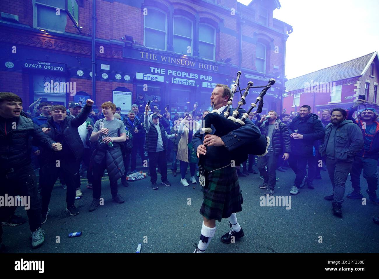 A man plays the bagpipes as Everton fans set off smoke flares outside ...