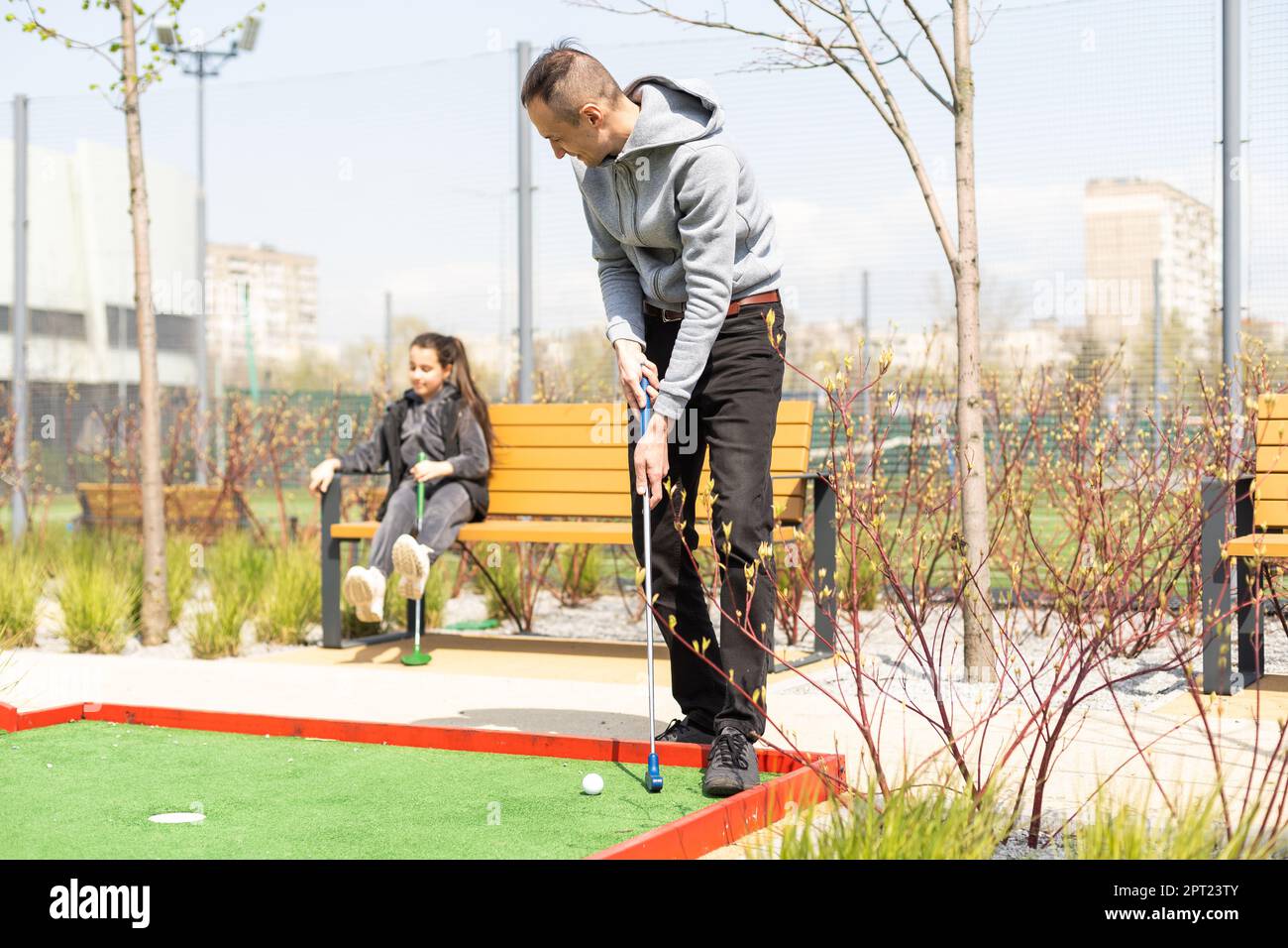 Family Time Playing Mini-Golf In The Summer Stock Photo - Alamy