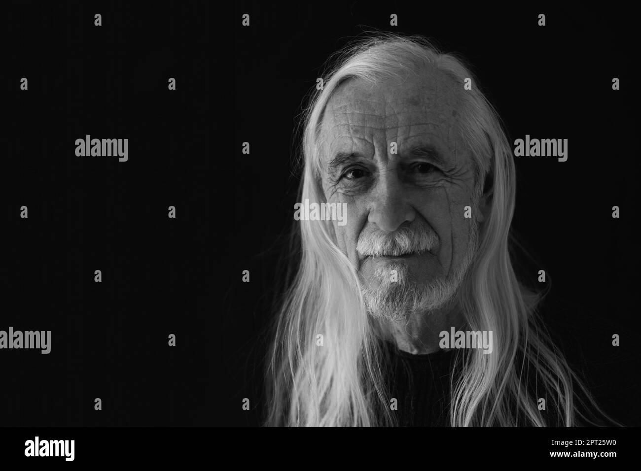 Low key studio black and white portrait of smiling attractive old man ...