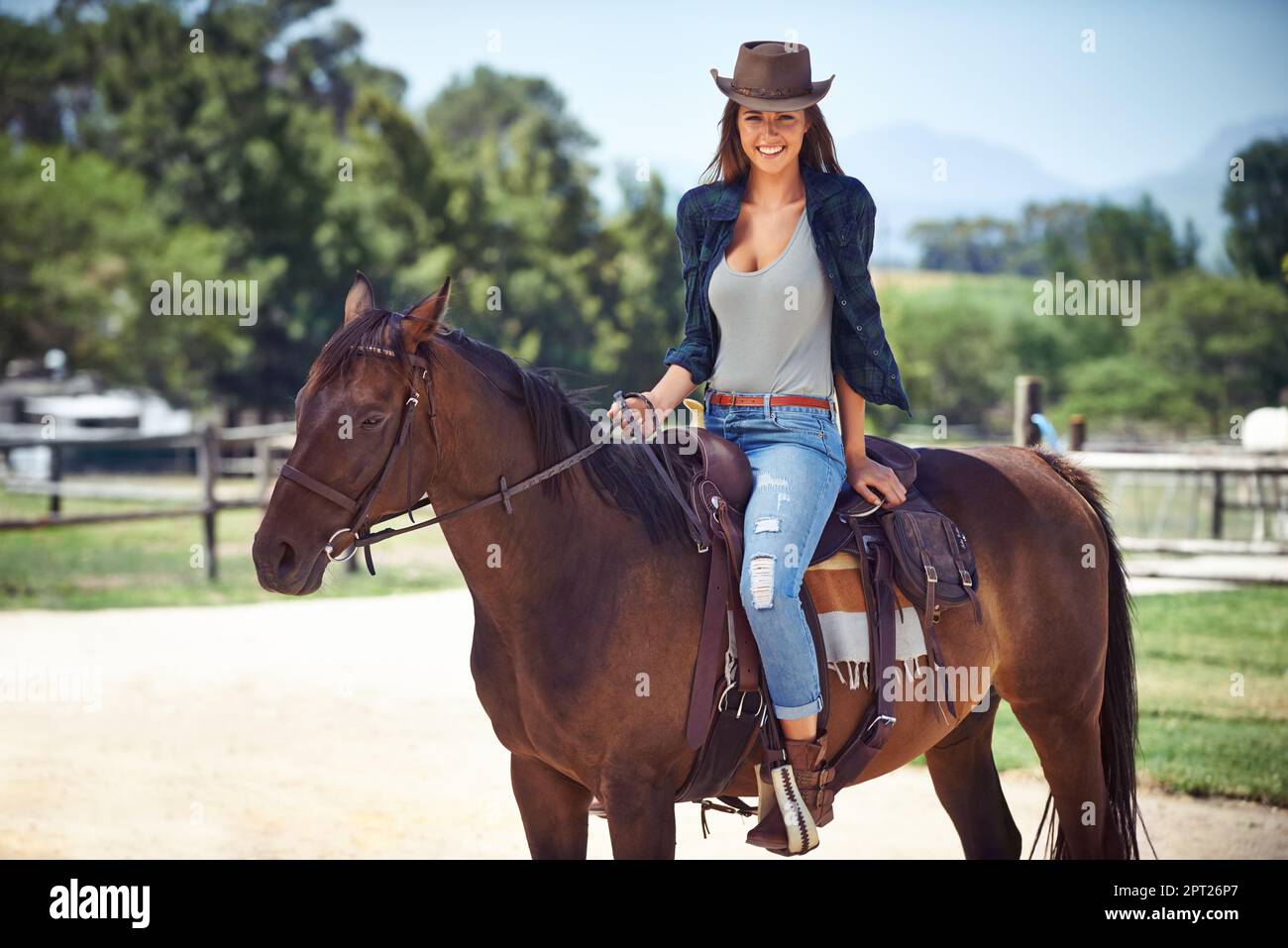 Loving the outdoors. Portrait of a gorgeous cowgirl sitting on her horse Stock Photo - Alamy