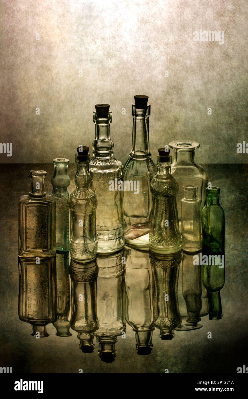 Still life with old glass bottles with reflection Stock Photo - Alamy