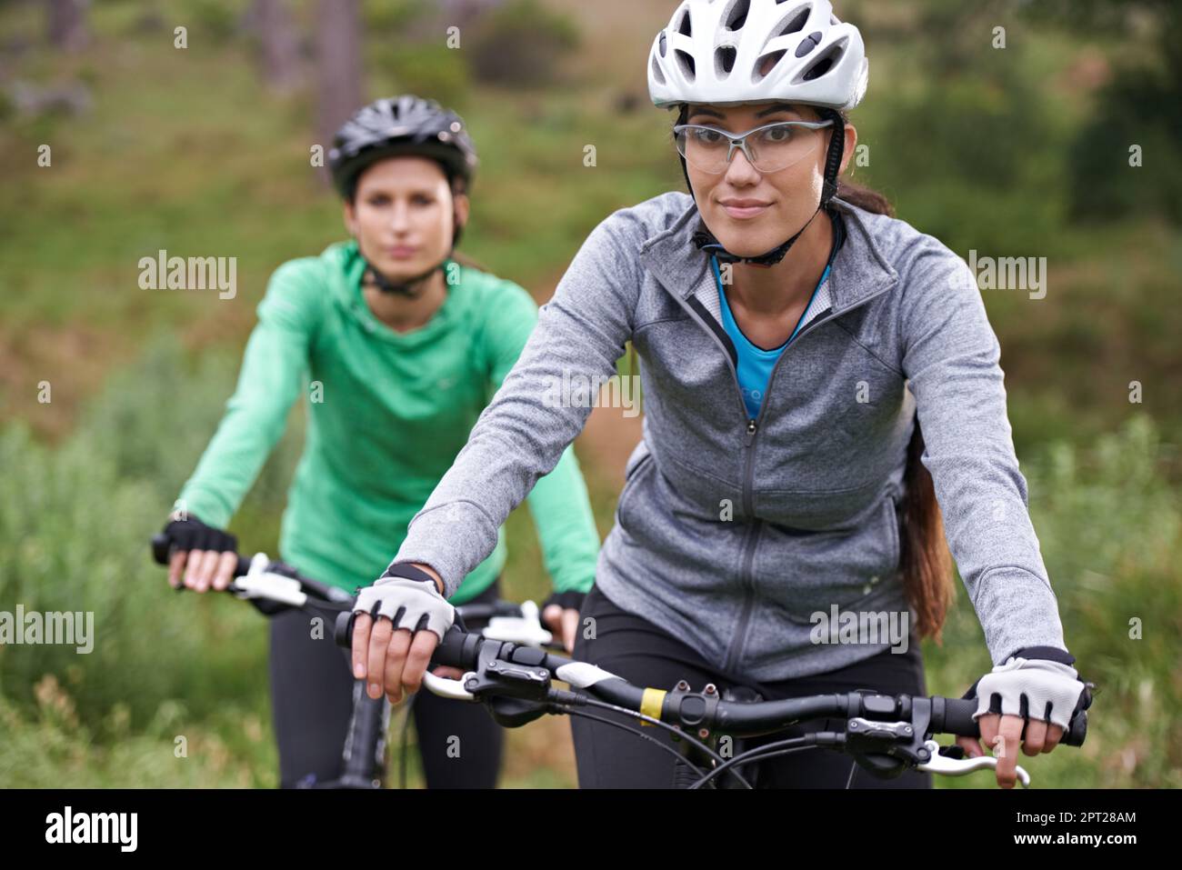 Staying fit together. Two young cyclists enjoying their ride along a ...