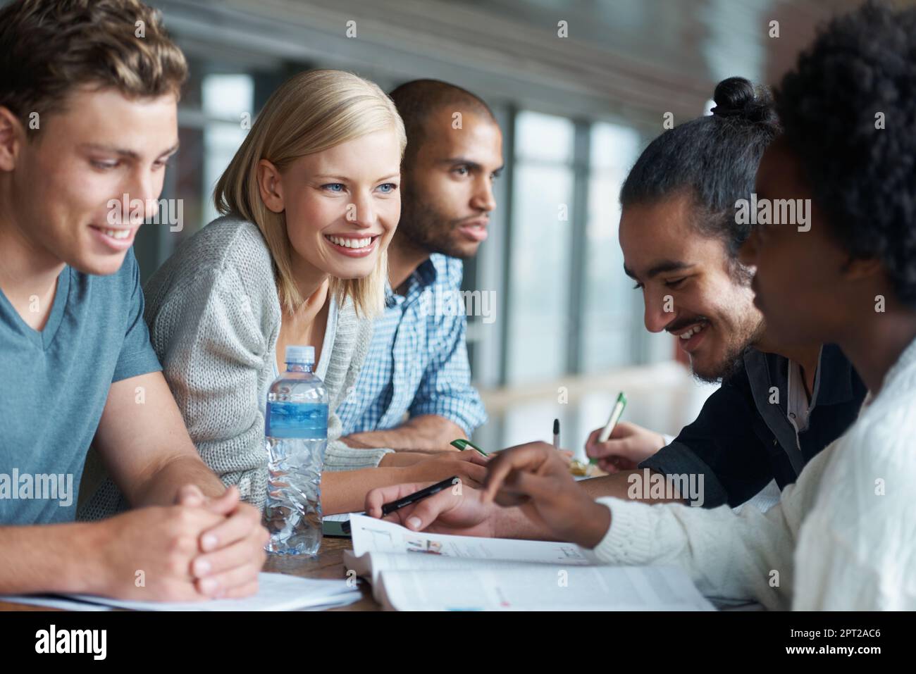 Coming up with all the answers. A group of college students sitting ...