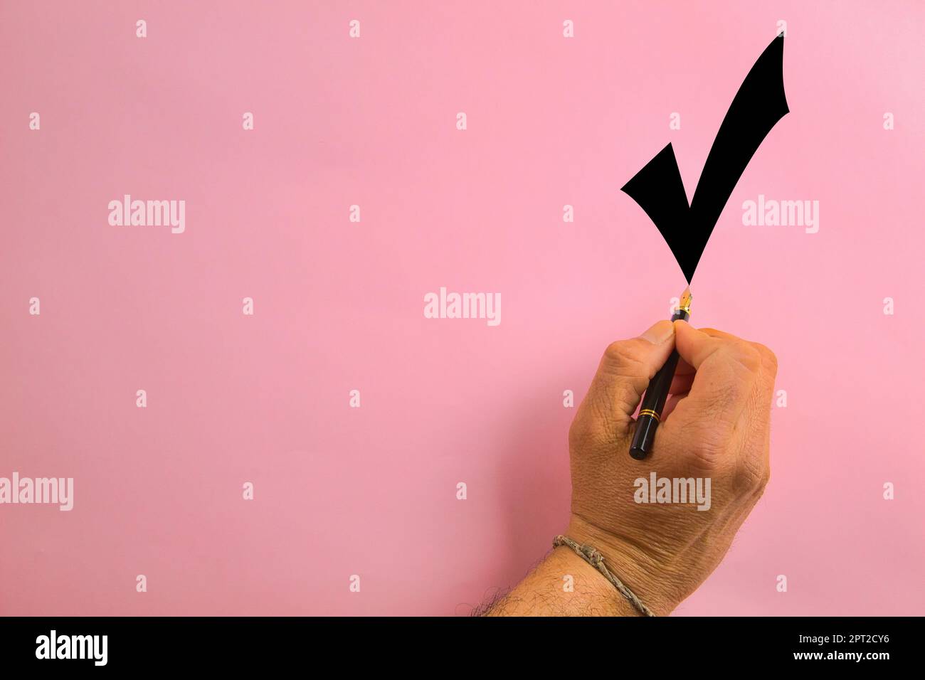 hand holding a pen writing an OK sign on a pink background Stock Photo ...