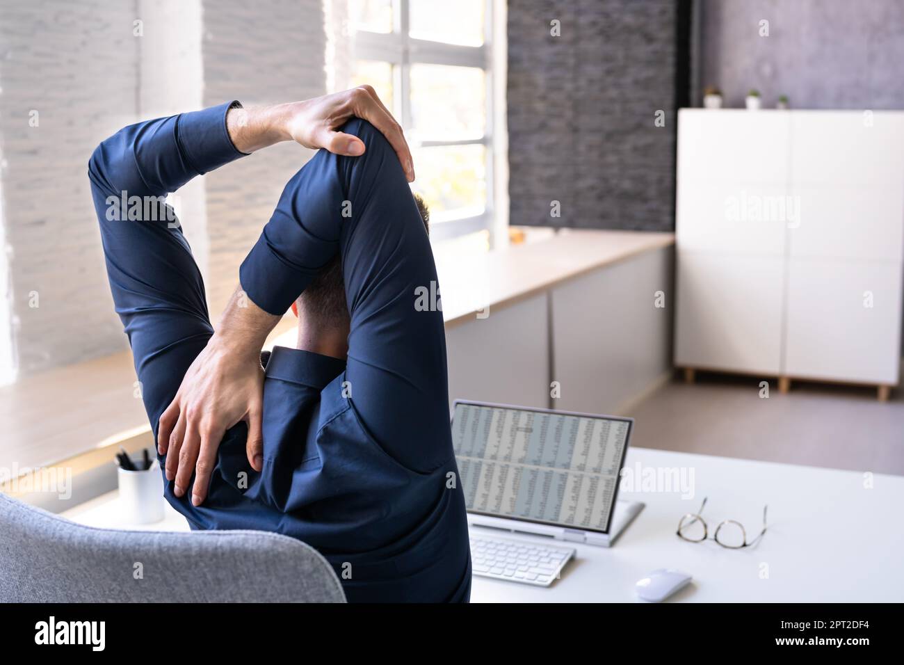 Employee Stretching At Office Desk At Work Stock Photo - Alamy