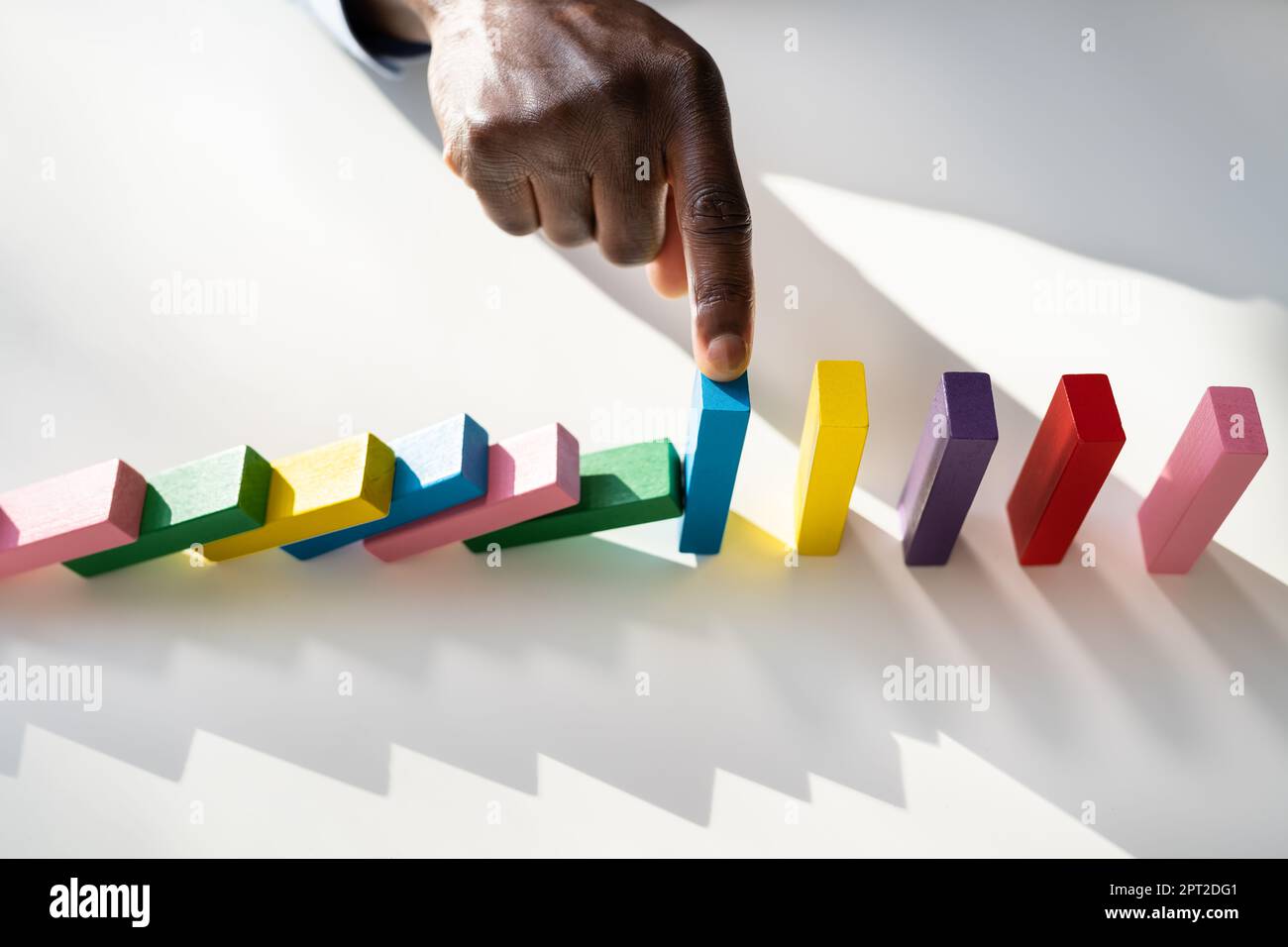 Domino Fall Prevention And Stop Using Hand Stock Photo - Alamy