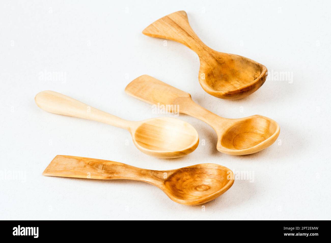 Four unique wooden spoons are on white background, wood carving concept Stock Photo - Alamy
