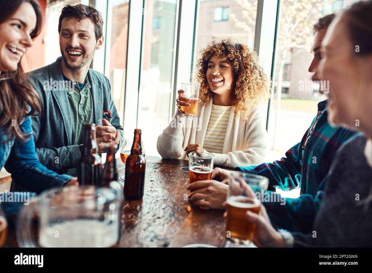 I sure love hanging out with them. young people having beers at a bar ...