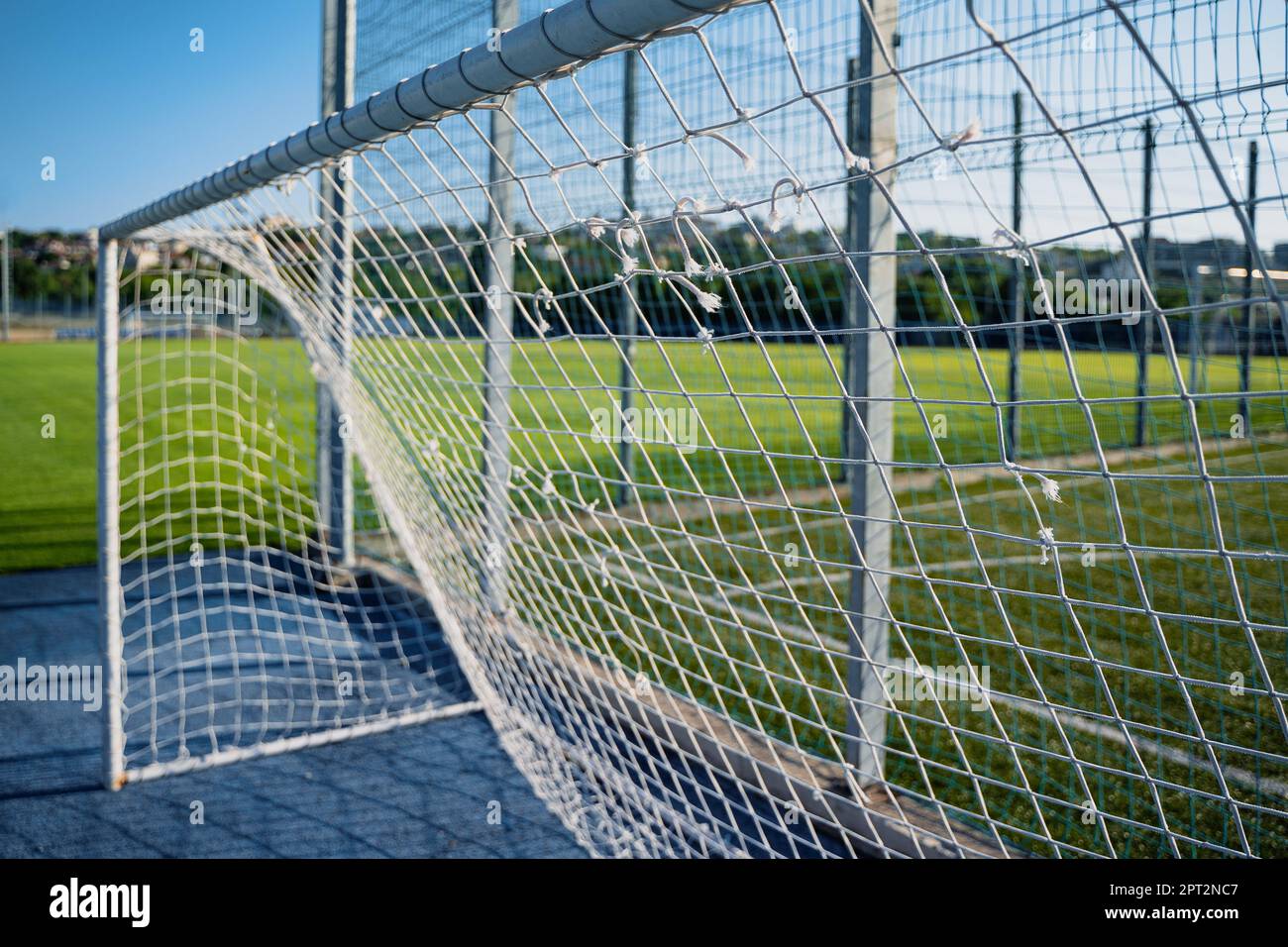 closeup of damaged soccer gate goalpost white rope net with knots and ...