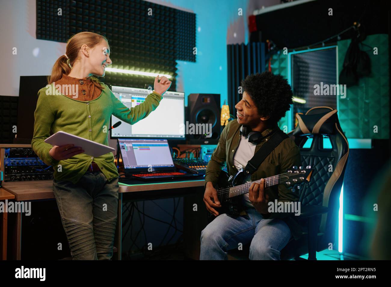 Young teenager girl singing song track with man guitarist record new ...
