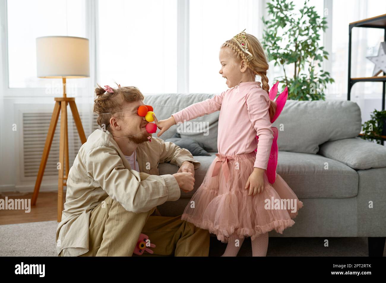 Playful father and daughter enjoy game with clown nose together, family ...