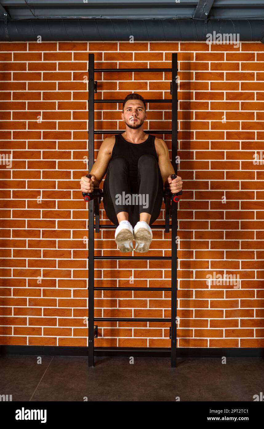 Handsome muscular man doing sport exercise on fit gym machine ...