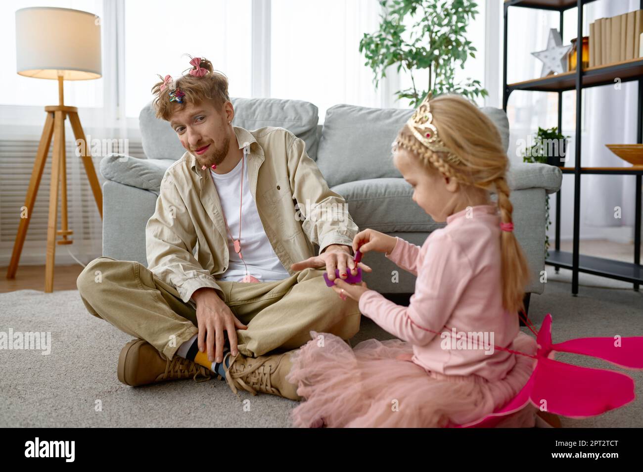 Daughter painting father nails with nail polish doing beauty procedures ...