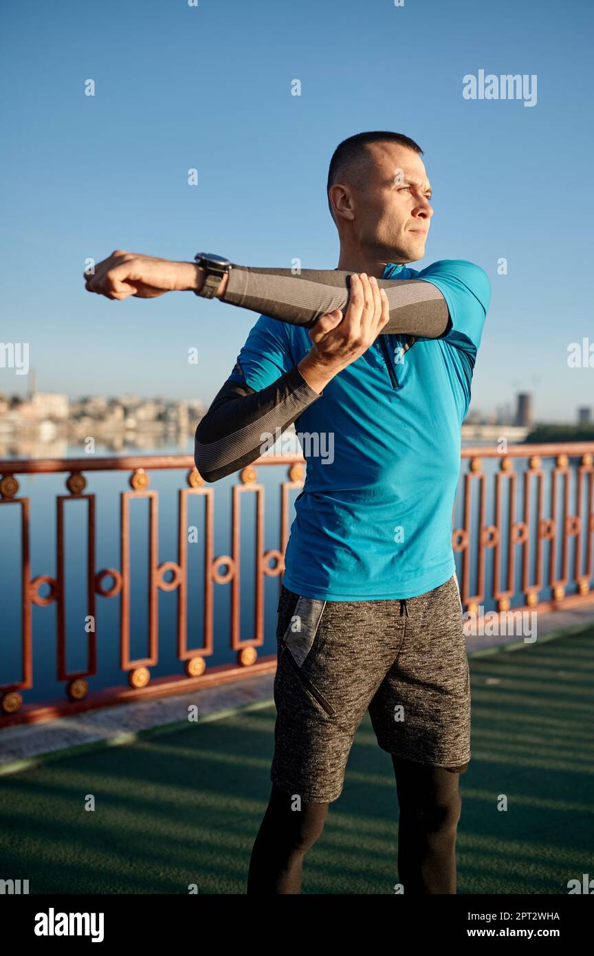 Fitness runner doing warm-up routine before speed running. Man ...