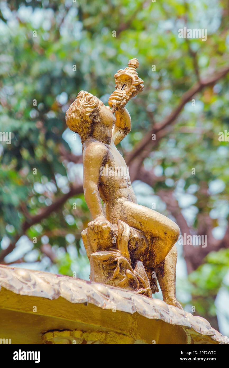 Golden boy statue on the fountain in the park Stock Photo - Alamy
