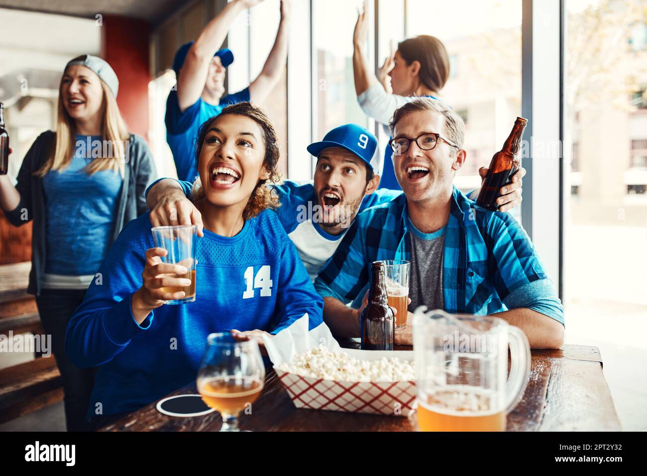 The atmosphere is electric. a group of friends cheering while watching ...