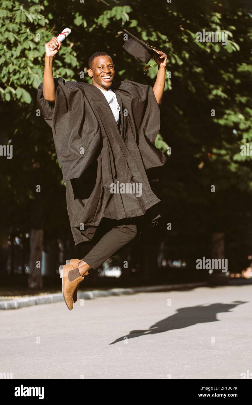 Happy african american graduate from university bouncing with happiness ...