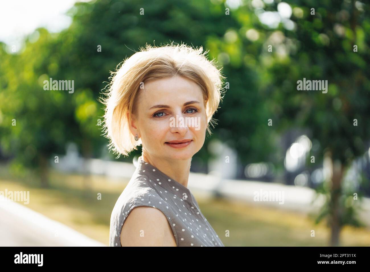 Portrait closeup of attractive looking woman standing half turn ...