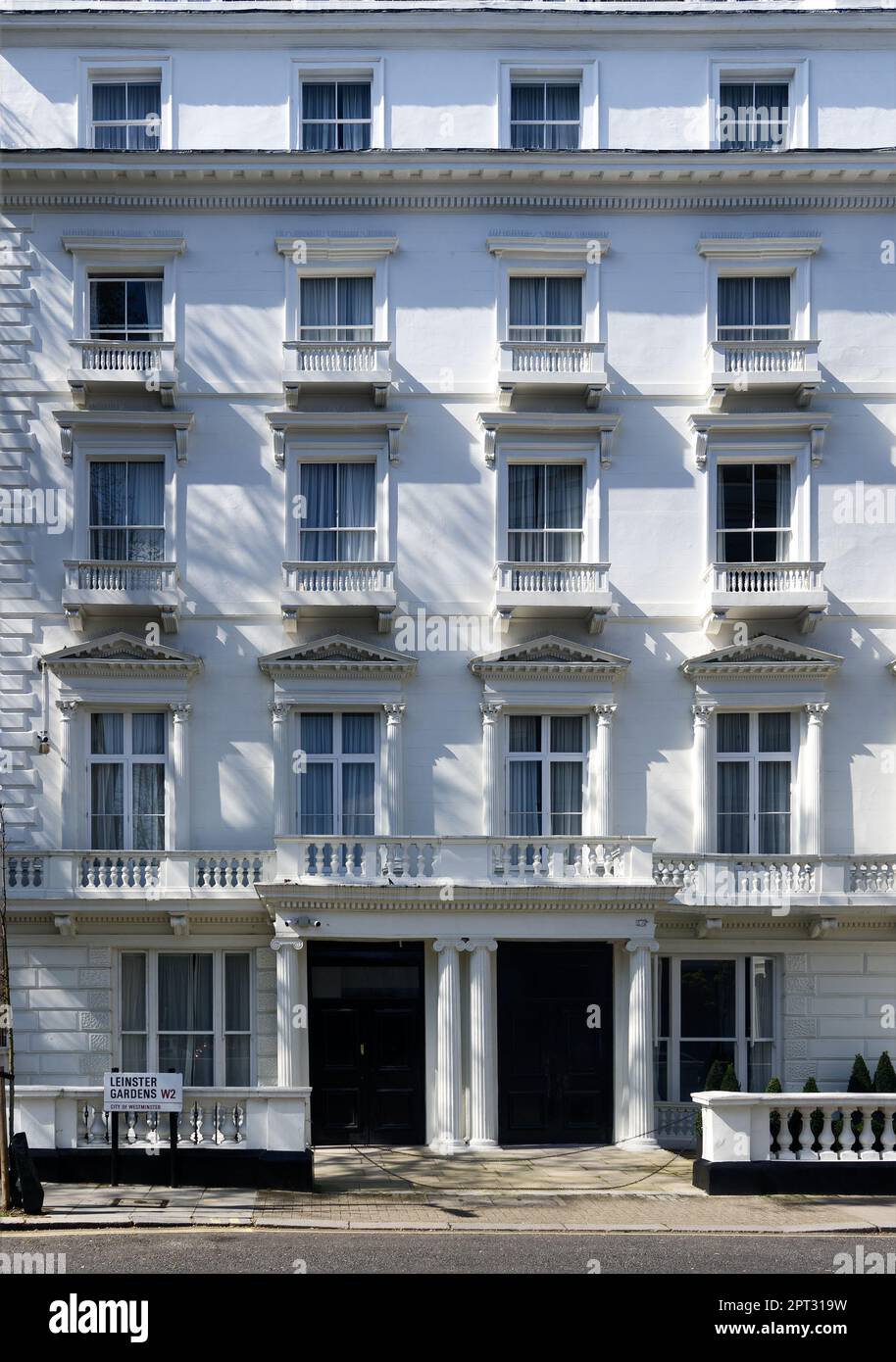 Rows of windows and balconies on a traditional white painted wall ...