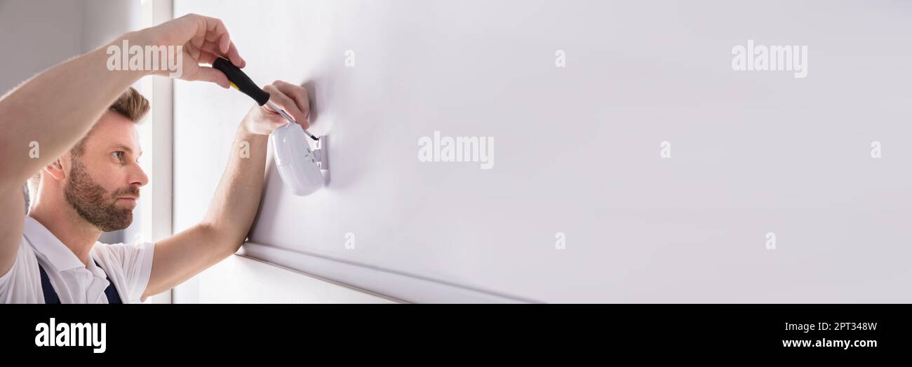 Security System Alarm Sensor. Electrician Man Repair Stock Photo - Alamy